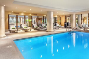 Uma área de piscina com espreguiçadeiras e plantas em vasos.