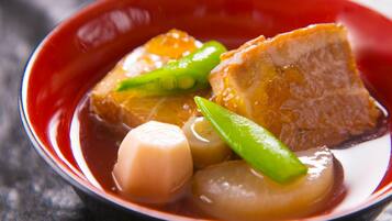 Uma tigela de sopa com tofu, vegetais verdes e uma fatia de carne.