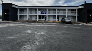 Um Stay Express Inn com estacionamento e um SUV cinza estacionado na frente.
