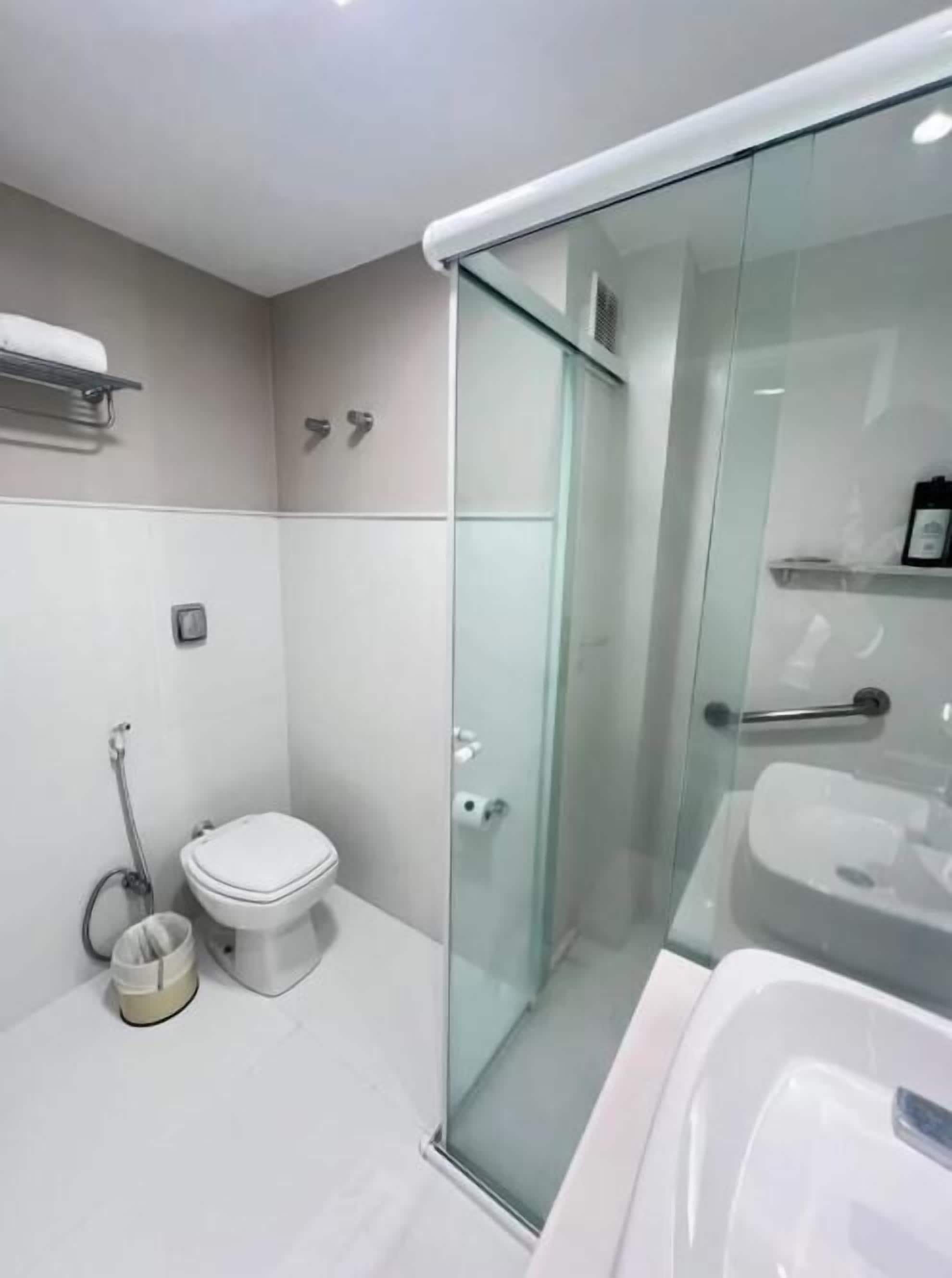 Um banheiro moderno com box de vidro, vaso sanitário e banheira.