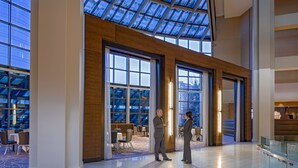 Um hall amplo com janelas grandes, teto alto e design de interiores moderno.