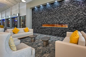 Um lobby moderno com parede de pedra, área de estar e lareira.