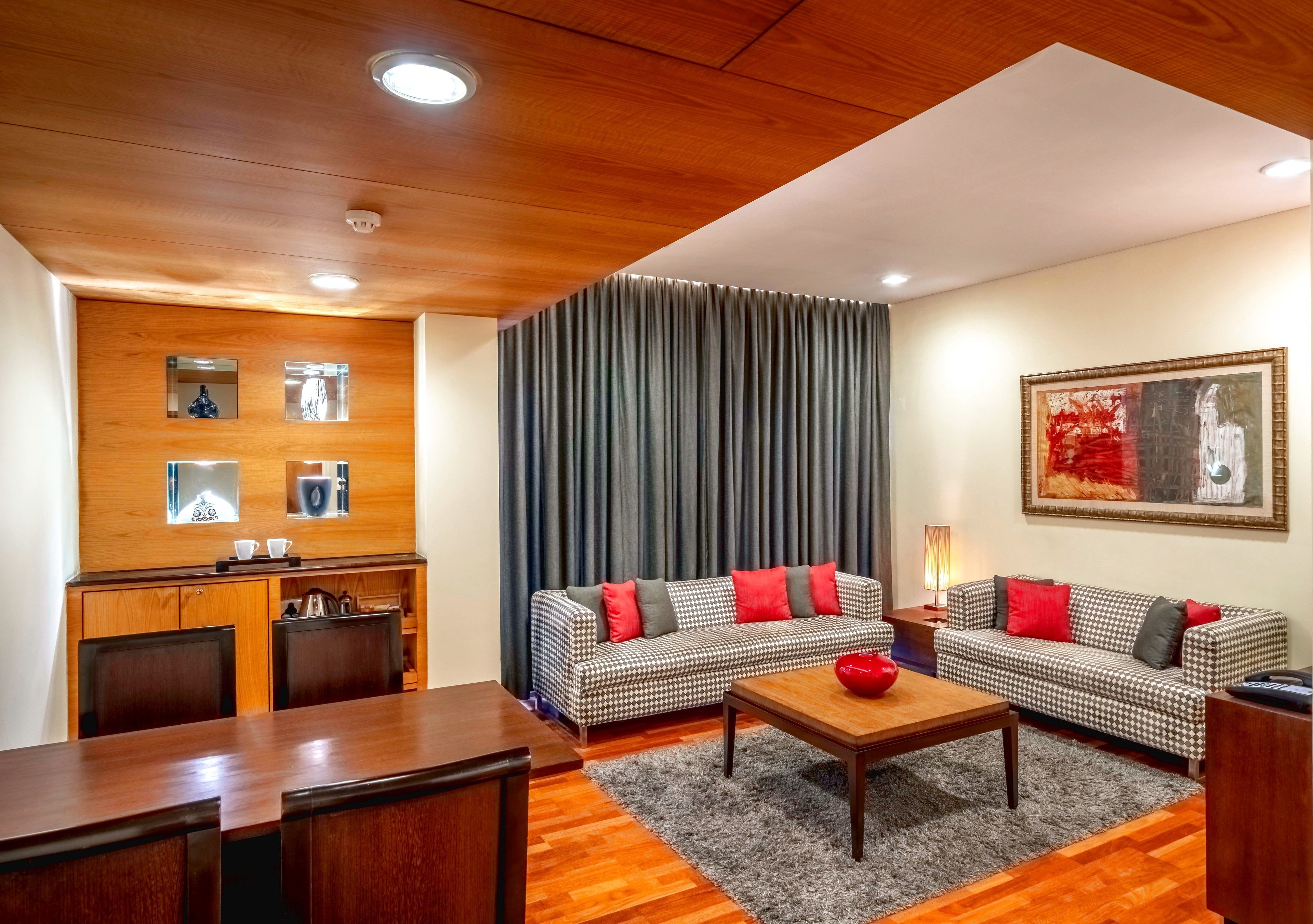 Uma sala de estar moderna com teto de madeira, um sofá, uma mesa de centro e um espaço de jantar.
