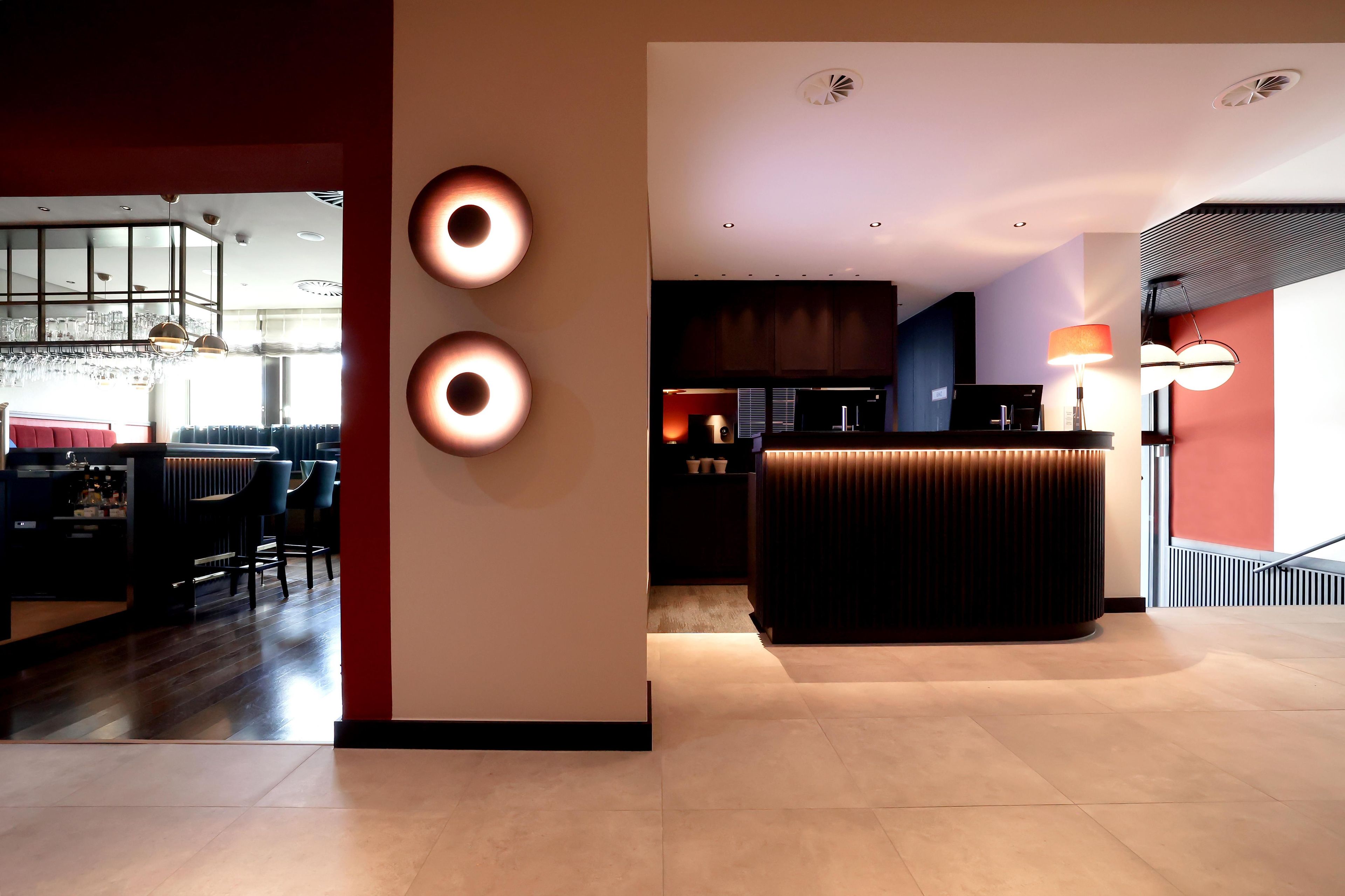 Decoração moderna com área de bar, assentos e balcão de recepção.