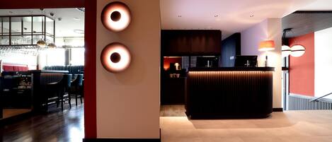 Decoração moderna com área de bar, assentos e balcão de recepção.
