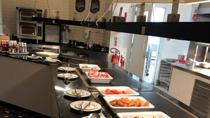 Disposição de buffet com diversos alimentos e utensílios.