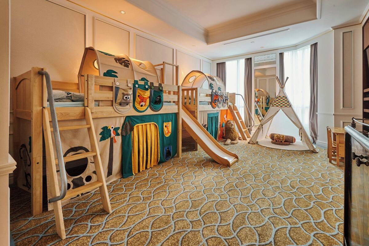 Espaço infantil com beliches, escorrega e tipi.