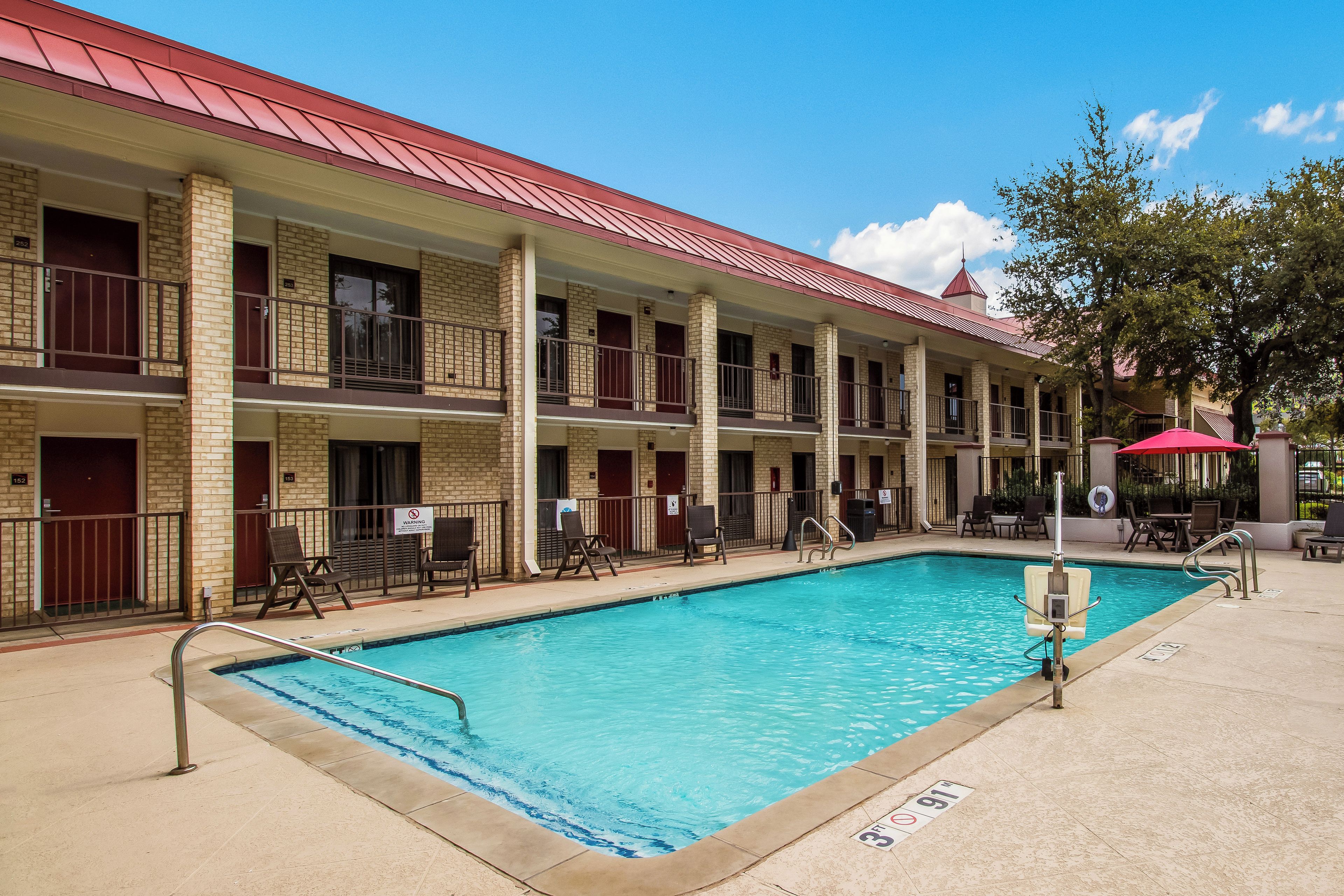 Um hotel com piscina, várias varandas e área de estar ao ar livre.