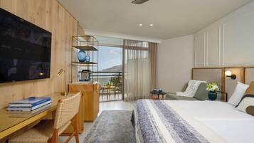 Quarto de hotel moderno com uma cama grande, uma escrivaninha com cadeira, TV e varanda com vista.