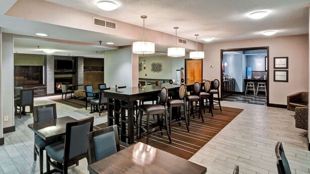 Um moderno hall de hotel com área de bar, assentos e lareira.