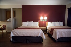 Quarto de hotel com duas camas, uma escrivaninha e uma cadeira.