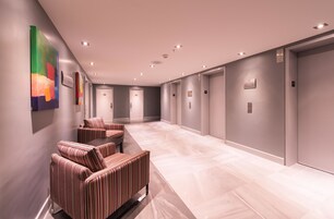 Um corredor com área de estar, várias portas e design moderno.