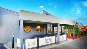 Uma cafeteria moderna chamada 'Beraldo', com design minimalista, mesas ao ar livre e vista clara para a rua.