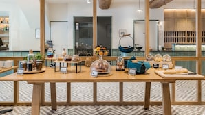 Um buffet de café da manhã com diversos alimentos e bebidas dispostos sobre uma mesa de madeira.