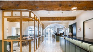 Interior moderno com divisória de madeira curva, piso estampado e área de bar com balcão verde.
