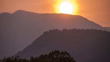 Silhueta de montanha com o sol se pondo ou nascendo ao fundo.