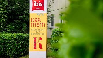 Placa de 'ibis Hotels' e 'ker mam' com restaurante, bar e espaço de coworking.
