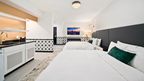 Quarto de hotel com cama, mesa de cabeceira e vista para a cidade.