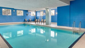 Piscina interior com paredes azuis e superfície de água límpida.