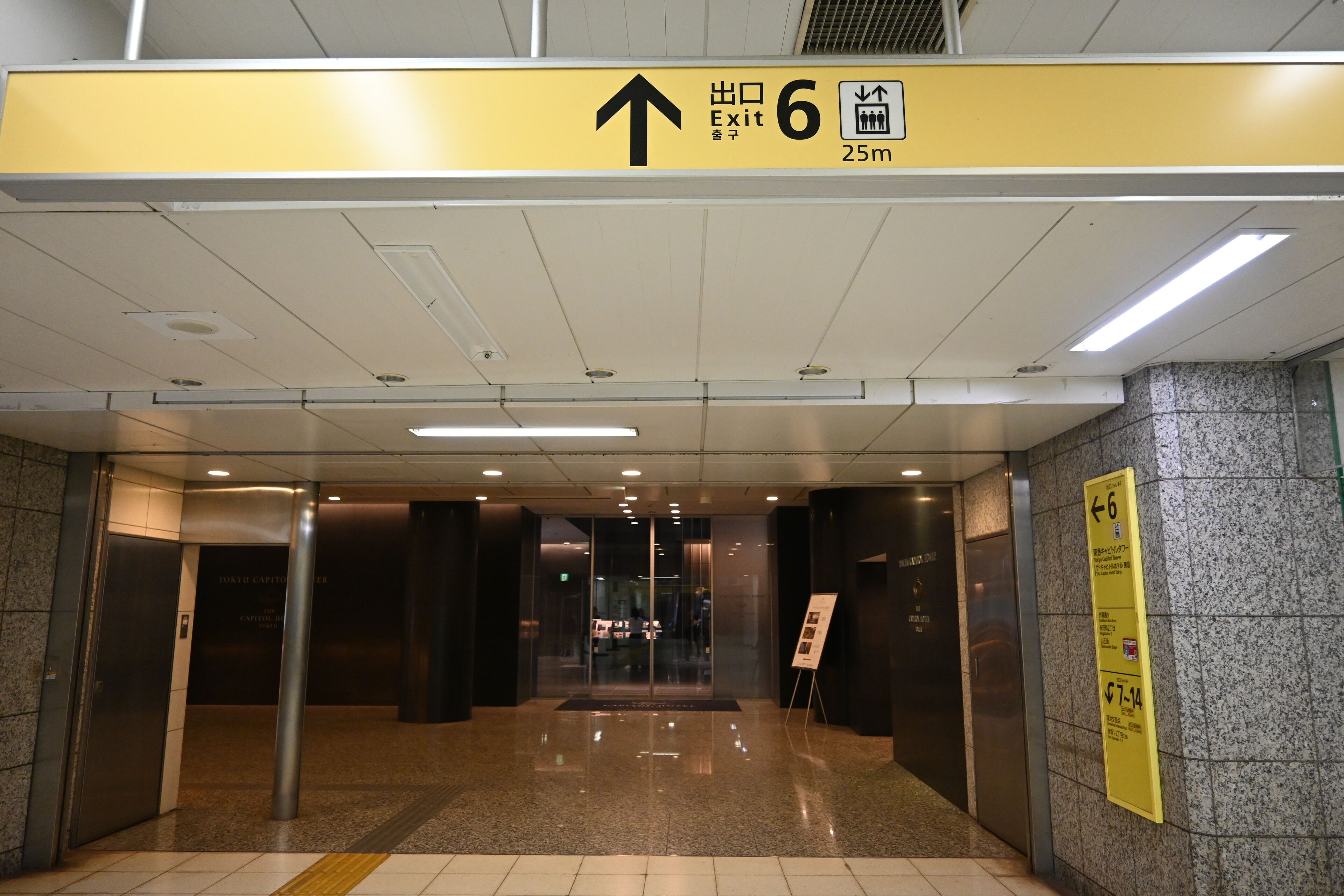 Corredor com placa indicando a Saída 6 e uma distância de 25 metros.