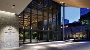 Exterior do Hotel Capitol Tokyo, com design moderno, amplas janelas de vidro e fachada de pedra.