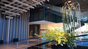 Um interior moderno com um mezanino, um arranjo de plantas central e um design de teto contemporâneo.