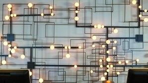 Um interior moderno com luminária de design geométrico e um balcão de recepção.