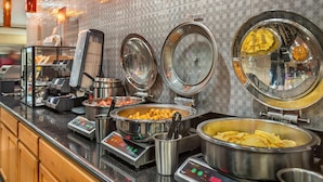 Disposição de buffet com diversos alimentos e utensílios de cozinha.