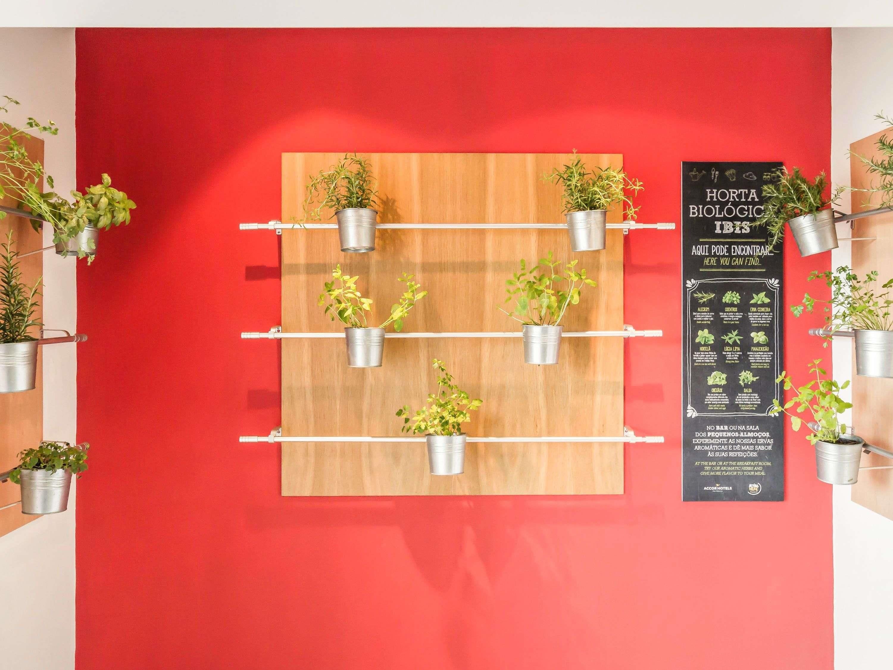 Paredes com jardim vertical e uma placa.
