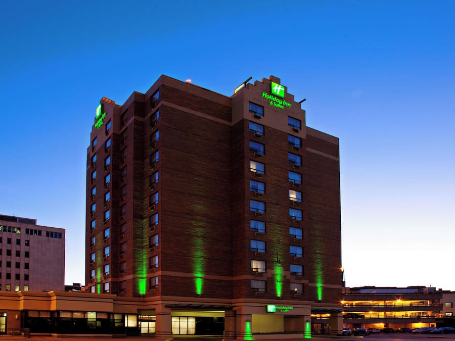 Um hotel Holiday Inn de vários andares com fachada de tijolos e sinalização iluminada.