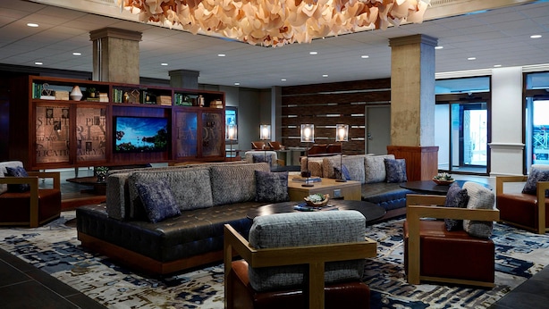 Um hall amplo com uma grande área de estar, televisão e estante de livros.