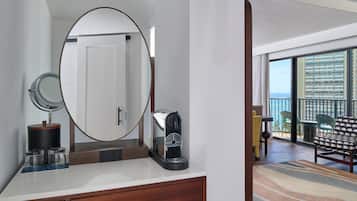 Quarto de hotel com toucador, máquina de café e vista para a varanda.