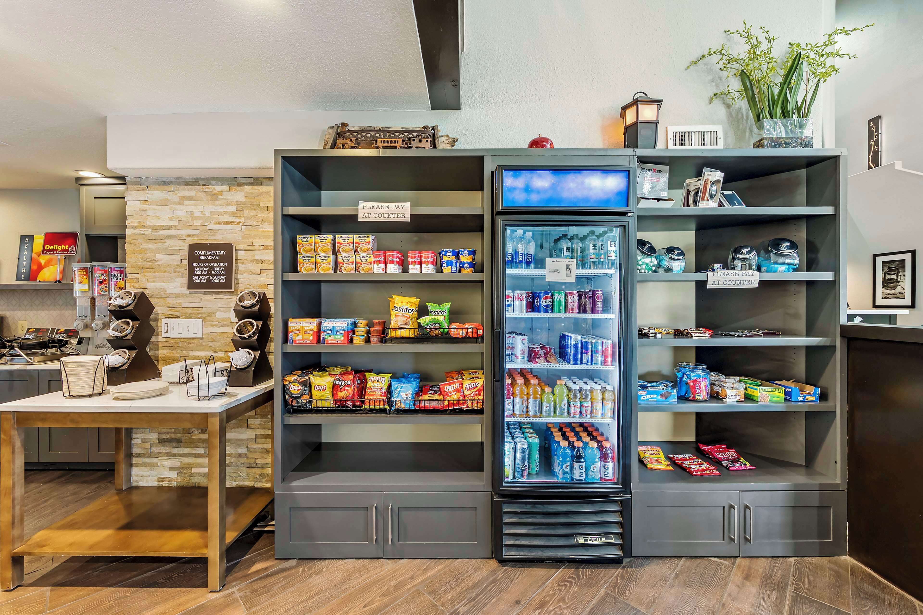 Uma máquina de autoatendimento para lanches e bebidas, com diversas opções de petiscos, refrescos e área refrigerada.