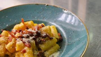Um prato de massa com queijo e bacon.