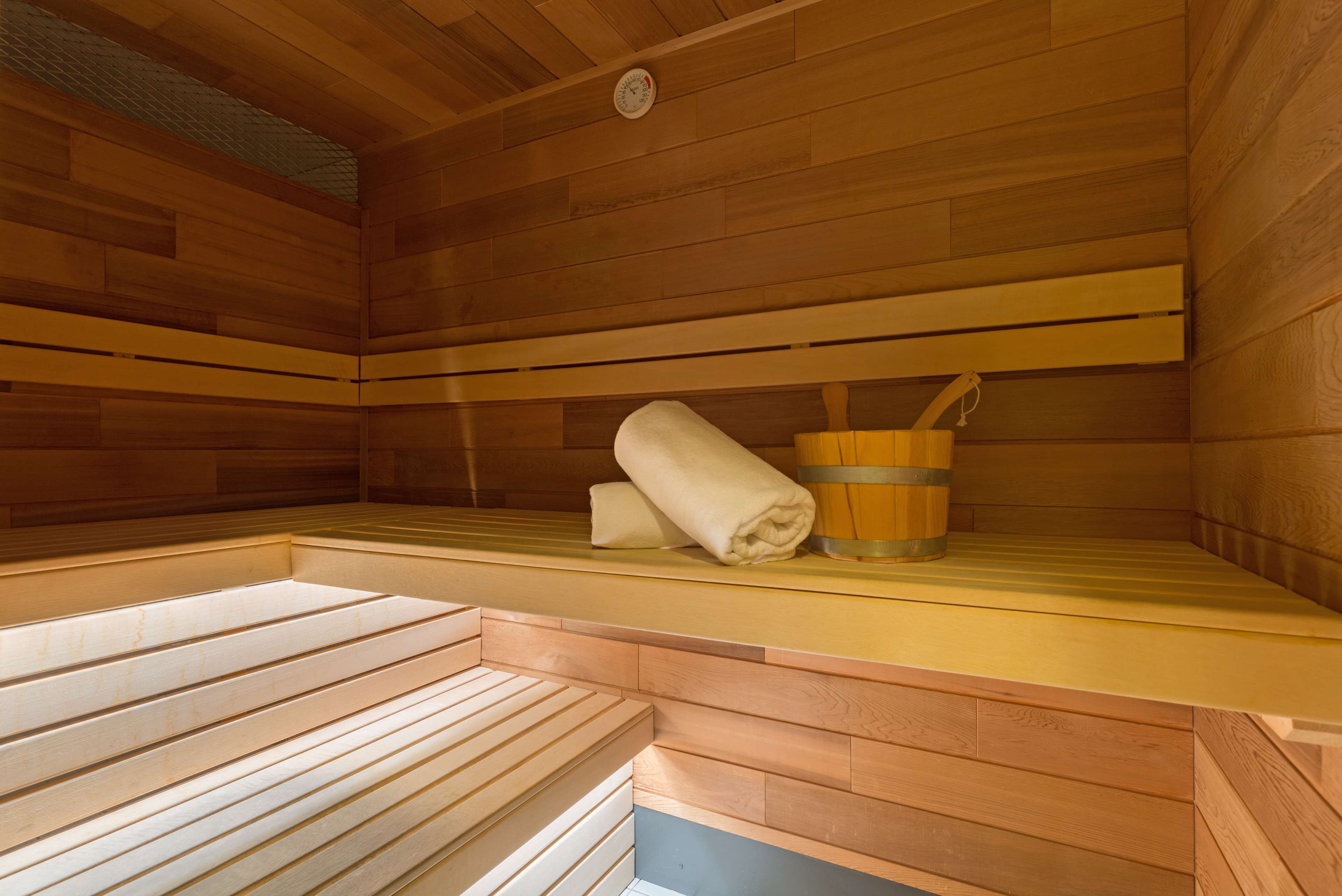 Uma sauna com bancos de madeira e um balde de madeira.
