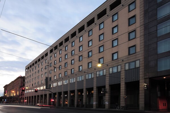 Um hotel com vários andares e design arquitetônico moderno, com uma série de varandas e grandes janelas.