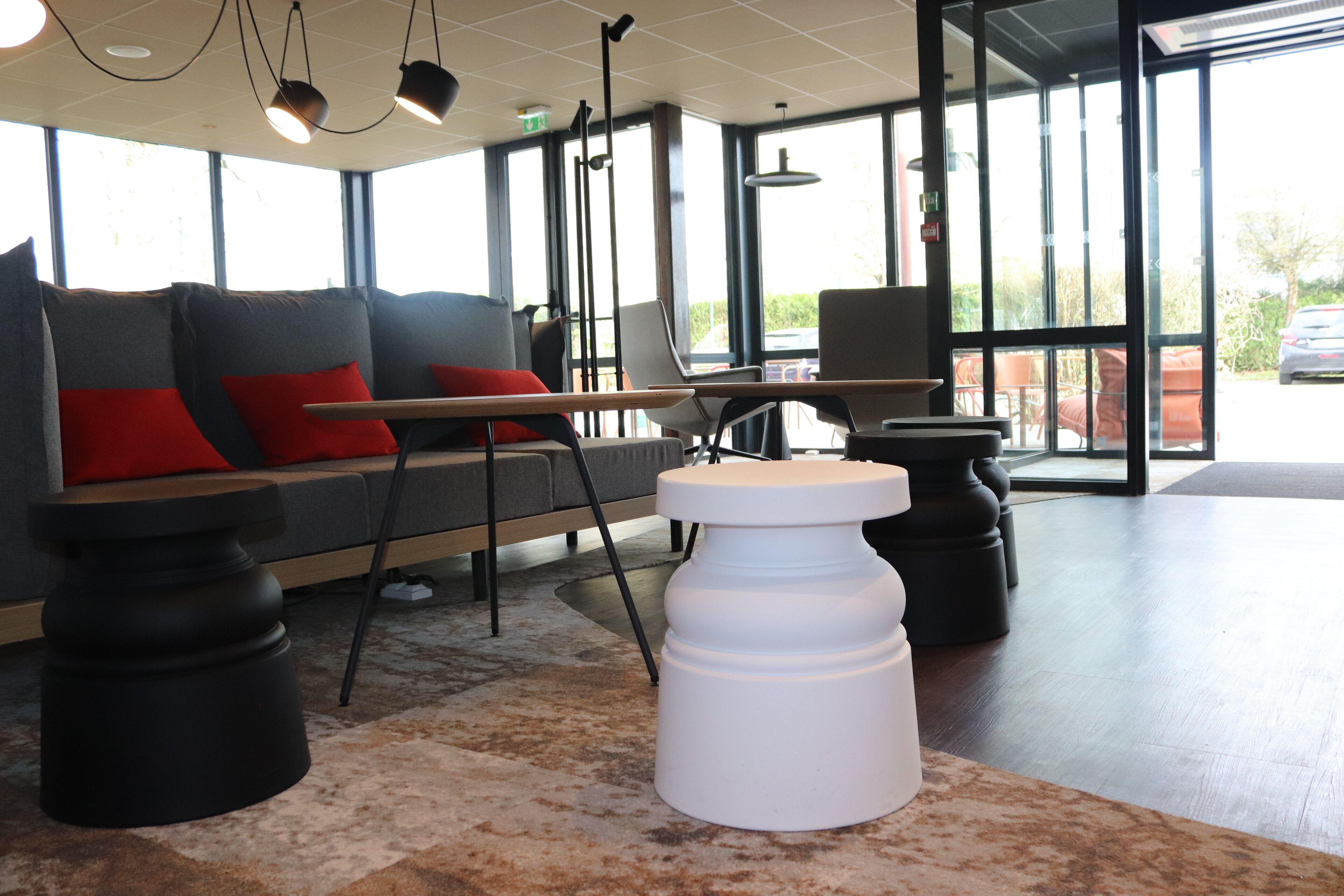 Decoração moderna com assentos, uma mesa e um pedestal branco singular.