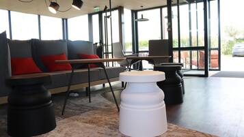 Decoração moderna com assentos, uma mesa e um pedestal branco singular.