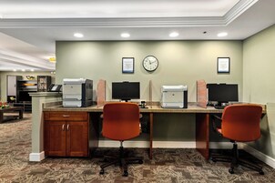 Uma área de recepção com dois balcões, computadores e cadeiras.