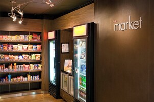 Exposição de petiscos com diversos alimentos embalados e uma área refrigerada para bebidas.