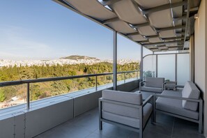 Uma varanda moderna com vista para um horizonte urbano e áreas verdes.