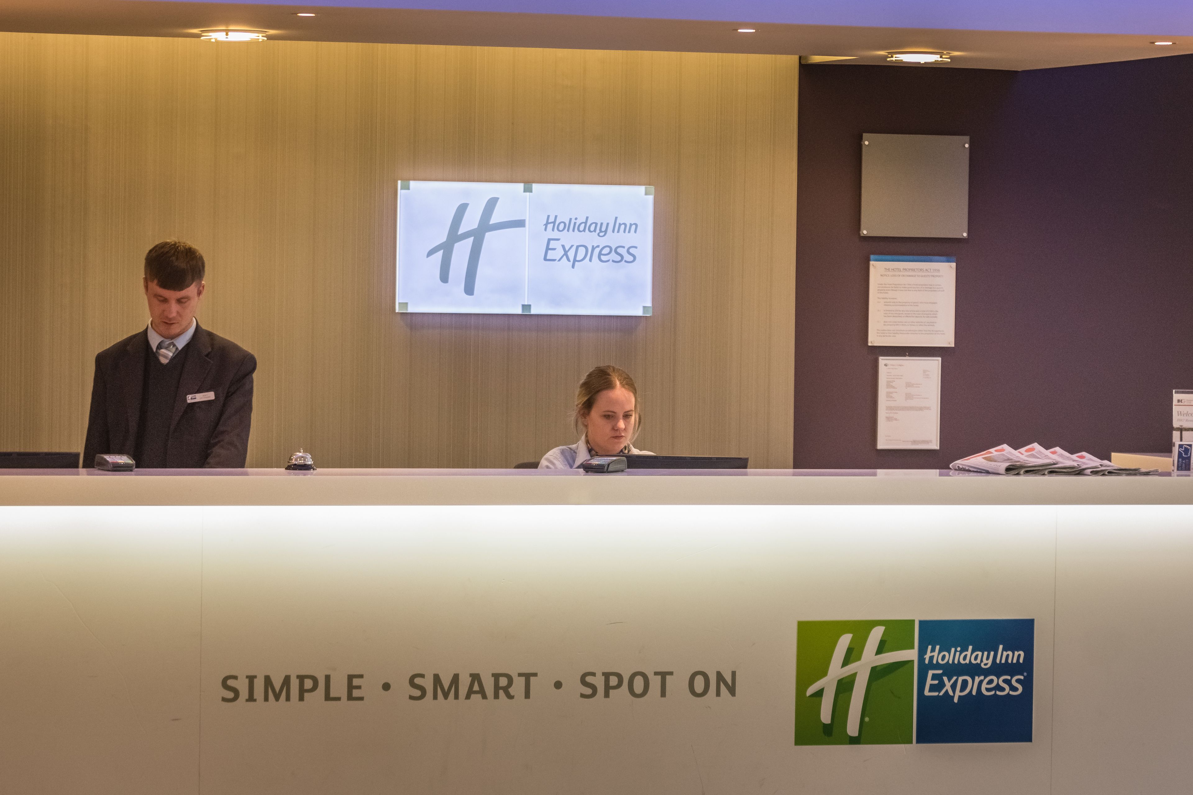 Balcão de recepção do Holiday Inn Express com um design simples, elegante e perfeito.