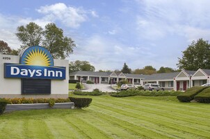 Um Days Inn com uma placa grande, várias unidades de motel e um gramado bem cuidado.