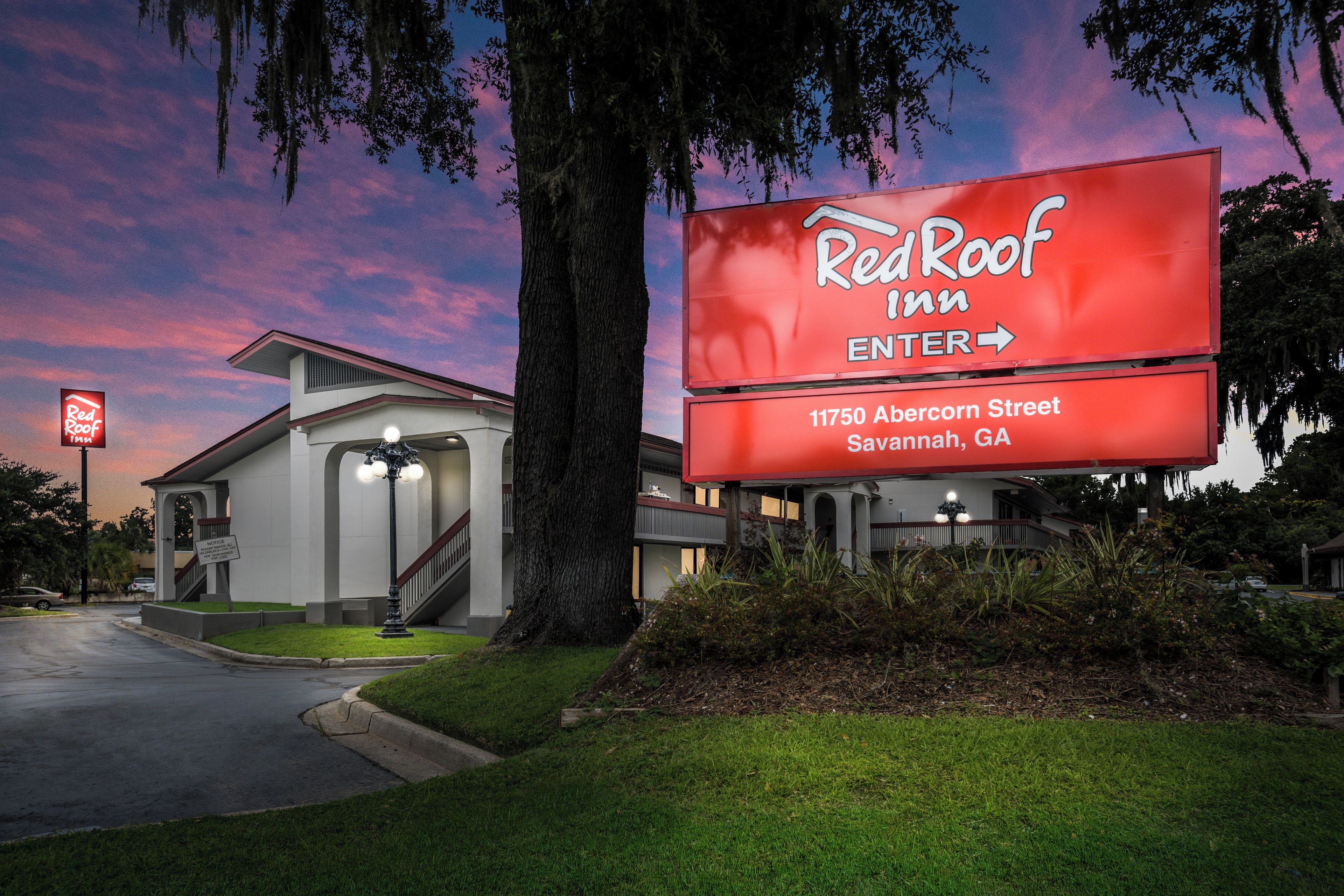 Placa da Red Roof Inn com uma seta indicando a entrada, localizada na Rua Abercorn, número 11750, Savannah, GA.