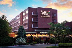 Um hotel com uma placa de destaque para 'Four Points by Sheraton' e um restaurante 'One Bistro' no nível térreo.