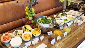 Buffet com diversos alimentos e um copo de suco.