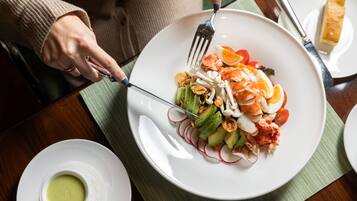 Prato de comida com garfo e faca sobre uma mesa.