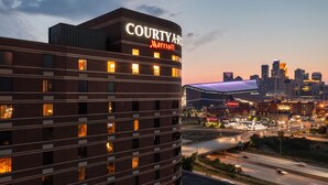 Um hotel Courtyard Marriott com fachada de tijolos moderna e janelas iluminadas.