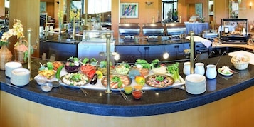 Disposição de buffet com diversas estações de comida e um balcão.
