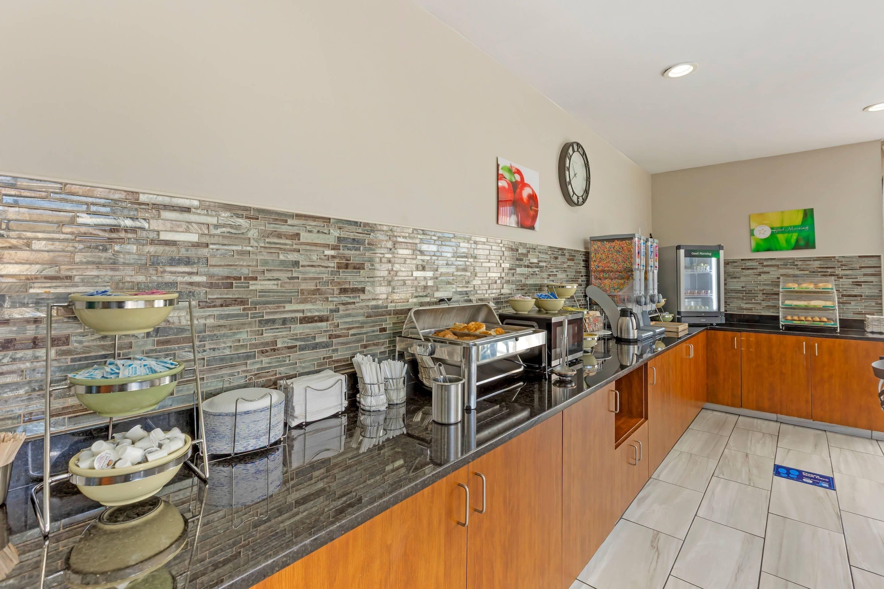 Cozinha moderna com painel de pedra, eletrodomésticos de aço inoxidável e um serviço de buffet.